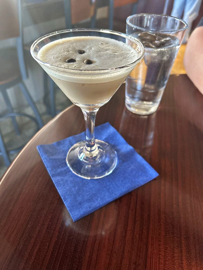 An espresso martini with three coffee beans floating like tiny boats&mdash;caffeine and alcohol joining forces for the perfect nightcap.