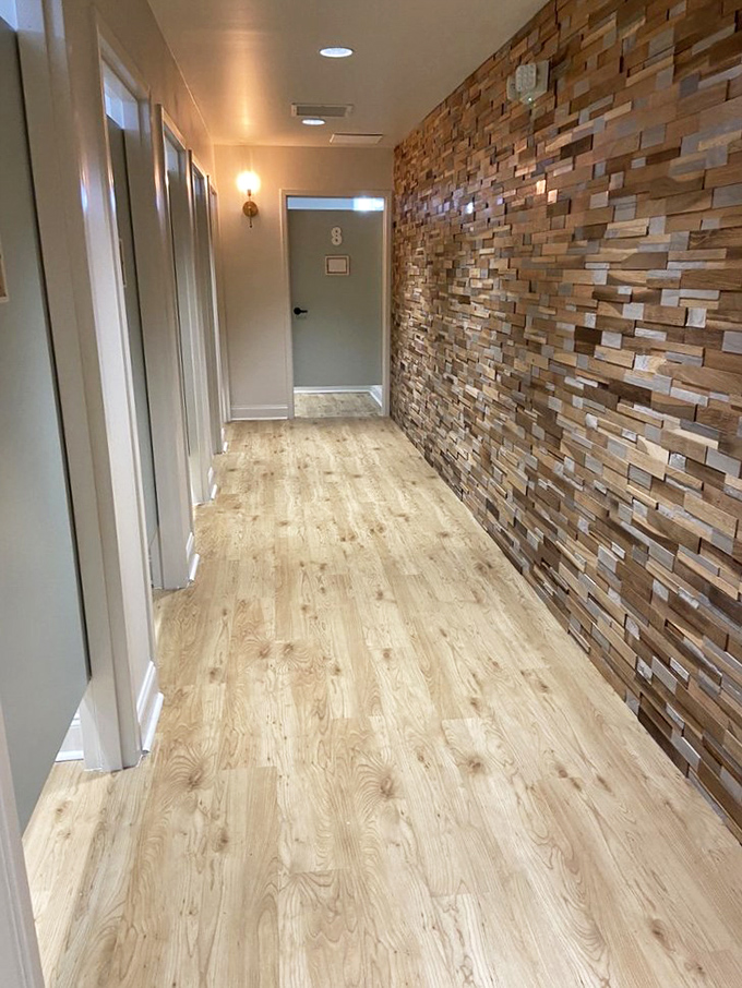 Fitting rooms that respect your dignity with proper lighting and space. That textured wood wall belongs in a high-end hotel, not a secondhand shop.