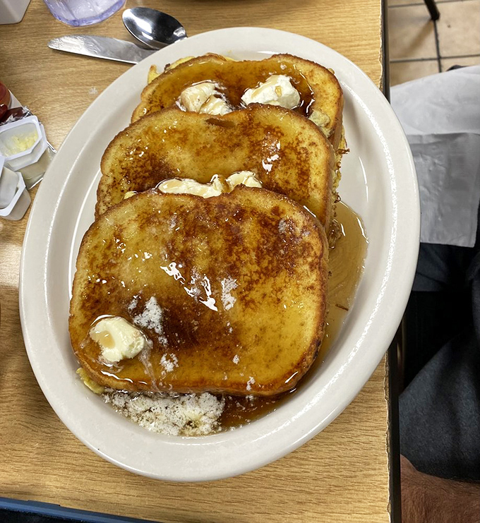 French toast that's crossed the line from bread to dessert and has no intention of looking back. That syrup pool is where breakfast dreams come true.