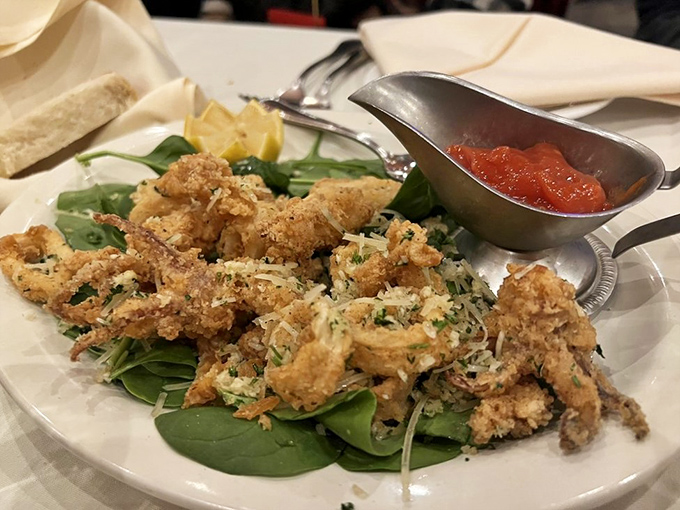 Crispy calamari perched atop fresh greens with marinara on standby. The perfect starter for those who believe fried food is a love language.