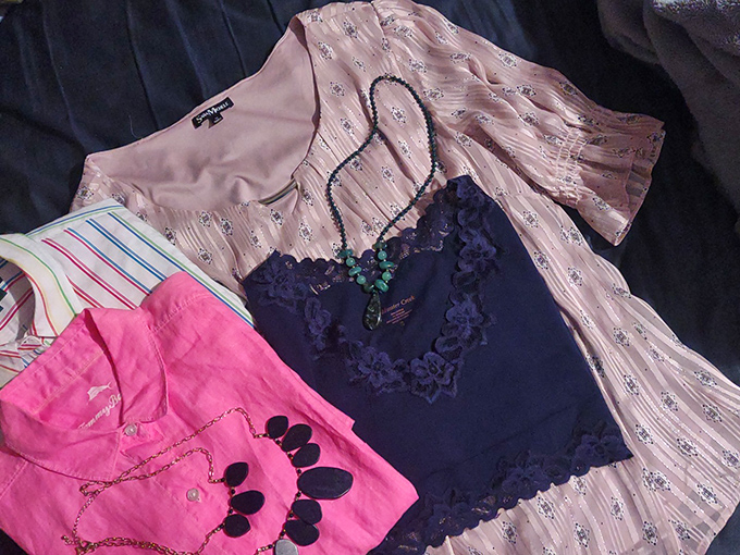 A textile still life of fashion possibilities &ndash; pink, navy, and patterns creating a secondhand symphony of style.