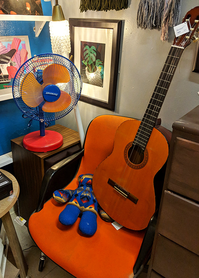 An orange guitar waits patiently for its next serenade, while a retro fan stands ready to be your biggest (and coolest) supporter.