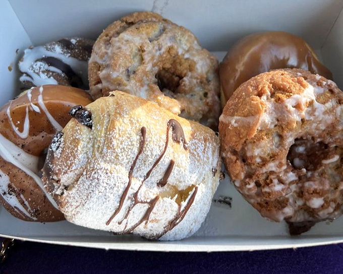 A box of joy containing more happiness than should legally fit in cardboard. Six different donuts, six different paths to bliss.