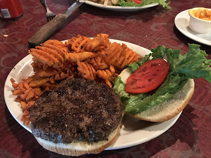 A hamburger steak that doesn't need a bun to make its point, accompanied by waffle fries that demand to be noticed.
