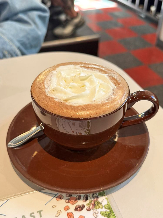 Not just hot chocolate, but a warm hug in ceramic form, with whipped cream melting slowly into the velvety depths below.