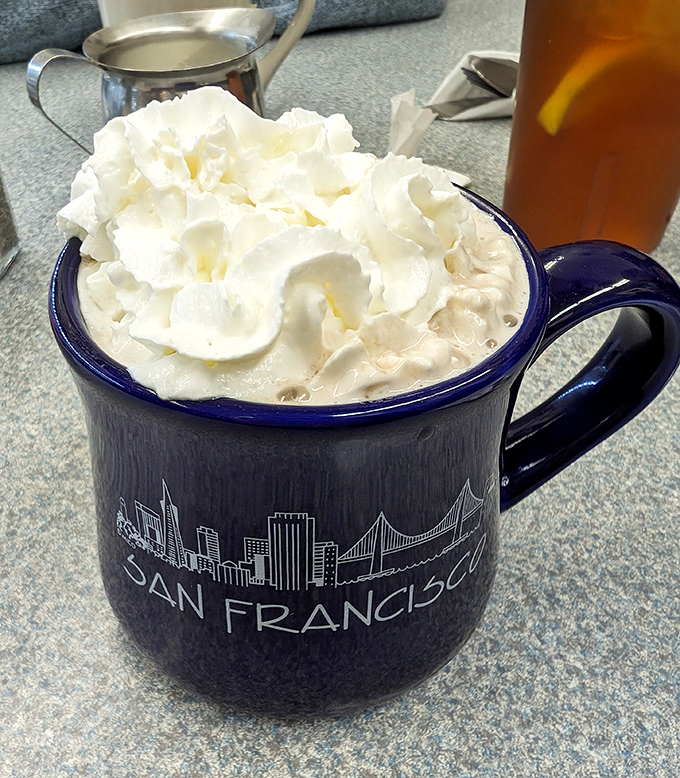 That whipped cream mountain atop hot chocolate in a San Francisco mug is the kind of delightful contradiction that makes life worth living.