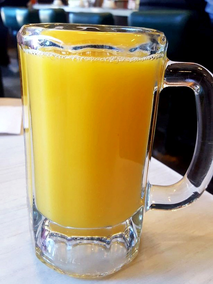 Orange juice in a mug the size of a small swimming pool—because proper breakfast hydration is serious business.