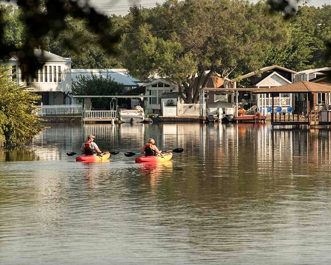 Kayakers glide through the reflective waters of Lake Granbury, where lakeside homes create a perfect backdrop for slow-paced adventure.