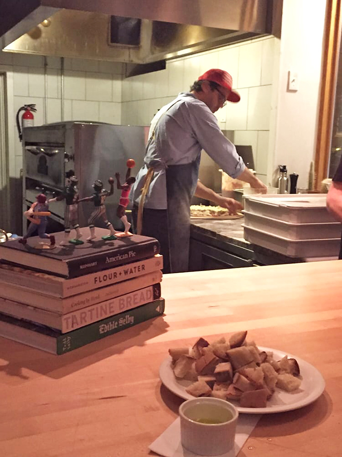 Where the magic happens&mdash;cookbooks stacked like sacred texts beside the tools of the trade. Serious craft at work.