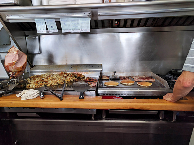 The kitchen's flat-top grill &ndash; where pancake batter transforms into golden discs of joy while home fries achieve crispy perfection.