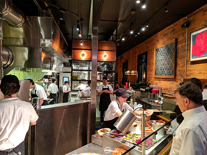 The open kitchen reveals the choreography behind the cuisine&mdash;a transparent testament to fresh ingredients and careful craftsmanship that builds trust with every order.