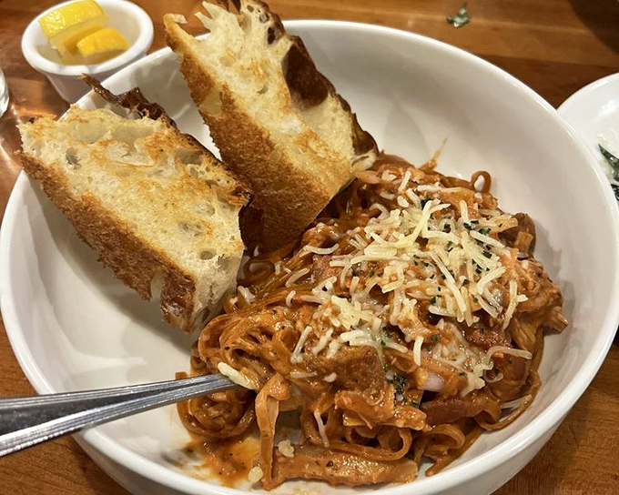 Pasta that doesn't just sit on the plate but seems to perform—twirled with sauce and topped with cheese that's practically begging to be photographed first.