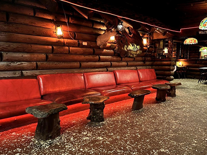 The waiting area's red leather bench – where anticipation builds and the aroma of grilled meat makes those minutes feel like delicious torture.