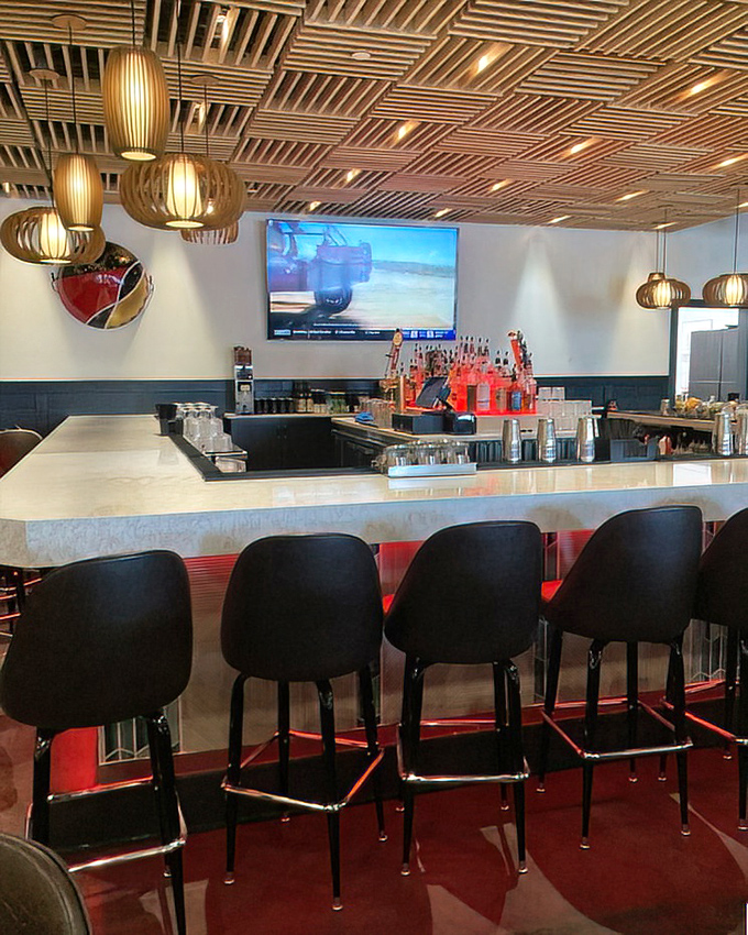 The bar doesn't just serve drinks&mdash;it's a marble-topped stage where liquid performances happen nightly under the watchful eye of wooden ceiling art.