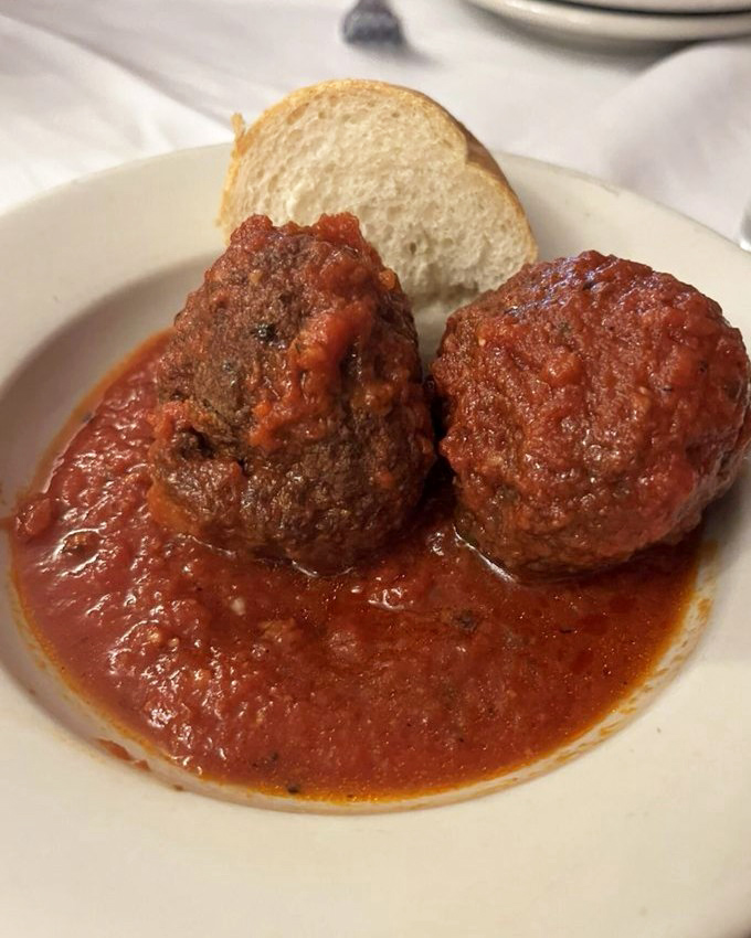 Meatballs that deserve their own area code&mdash;tender, savory planets orbiting in a sea of that famous red sauce. The bread is non-negotiable.
