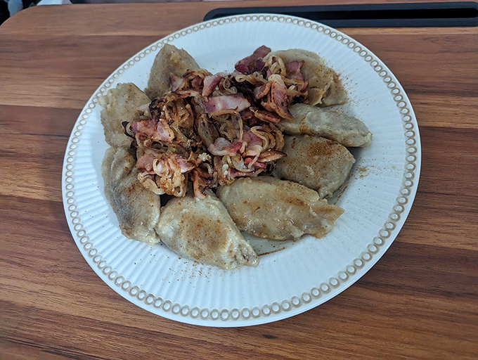 A circle of golden-brown pierogies crowned with a tangle of caramelized onions—this isn't just dinner, it's an edible work of art.