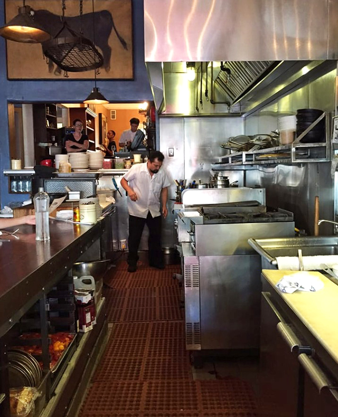 Behind the scenes where the magic happens—chefs working with focused precision in a kitchen that's both efficient and soulful.