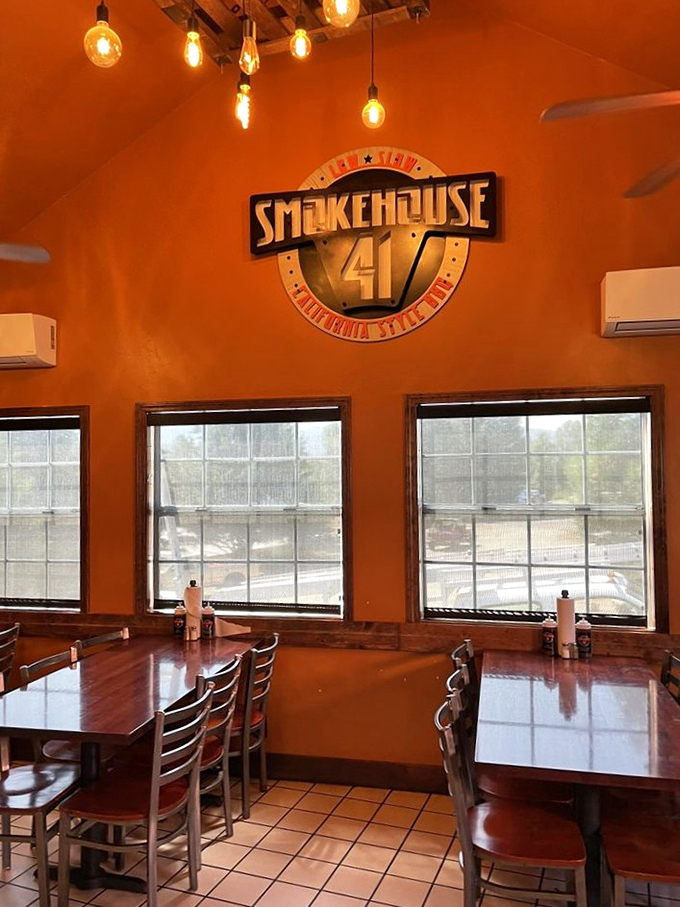Warm orange walls and Edison bulbs create the perfect backdrop for the Smokehouse 41 logo &ndash; a promise of good things to come.