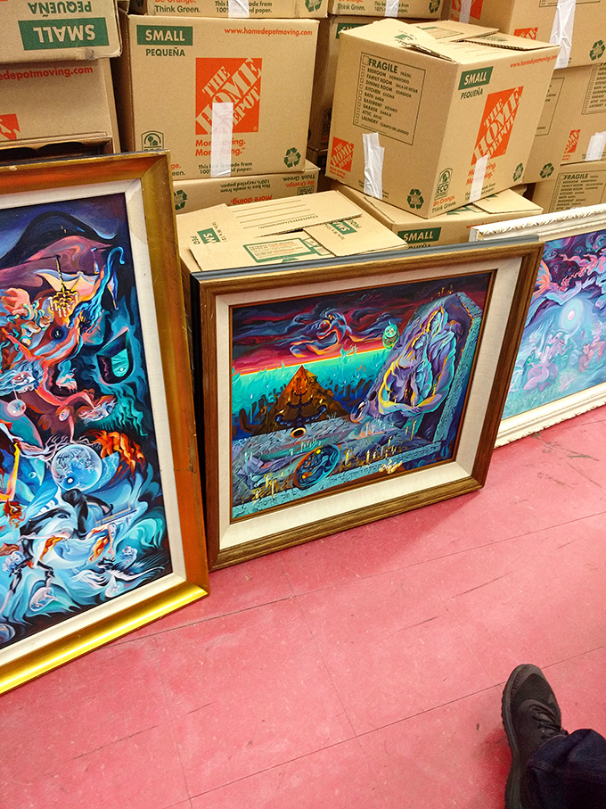 Vibrant artwork leans against moving boxes, proving that one person's decluttering project becomes another's living room masterpiece.