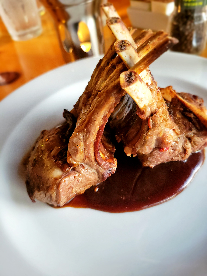 Rack of lamb so perfectly frenched it could teach etiquette classes, bathed in a reduction that glistens like liquid rubies.