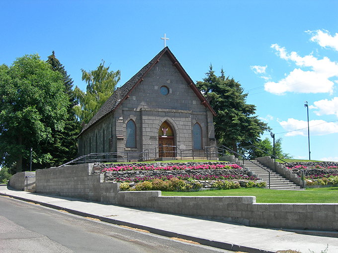 Sacred Heart Catholic Church rises above colorful gardens, offering both spiritual comfort and architectural beauty to this rural community.