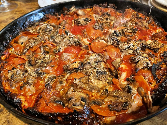 The holy trinity of pizza toppings&mdash;sausage, pepperoni, and mushrooms&mdash;having a flavor party in a perfectly seasoned cast iron pan.