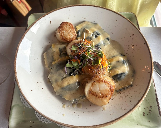 Ravioli and scallops sharing a plate like old friends reuniting, with microgreens adding a splash of color to the reunion.