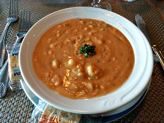 A velvety seafood bisque that probably contains more treasures from the ocean than some small fishing villages. That rich coral color promises depth of flavor that delivers.