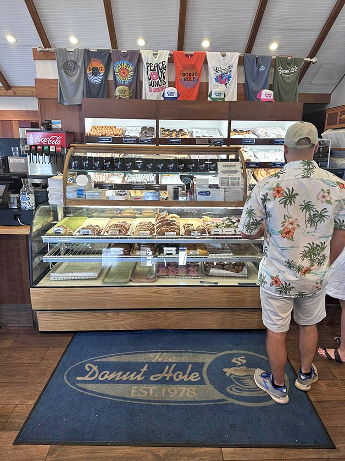 The merchandise hanging above the bakery case says, "Yes, you can take the Donut Hole experience home." The t-shirts are souvenirs that won't get stale!