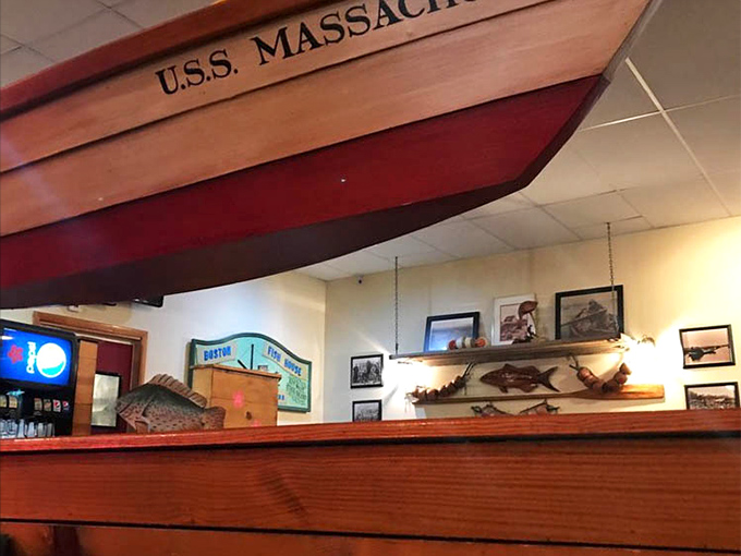 The USS Massachusetts boat display watches over diners like a guardian of authentic New England seafood traditions.