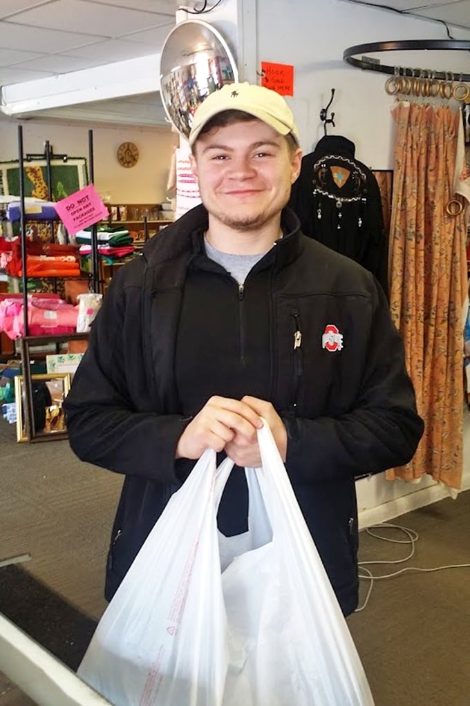The face of thrift store victory&mdash;a shopper with that unmistakable "I just scored big time" grin. Those white bags hold treasures that cost less than a fancy coffee.