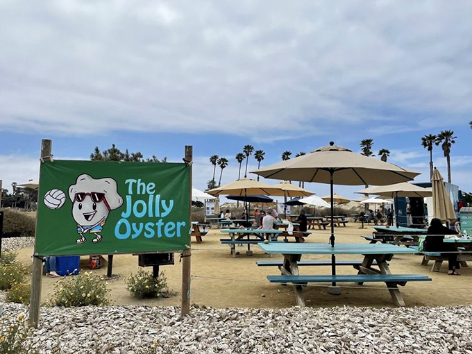 The cheerful cartoon oyster mascot welcomes you to seafood paradise. That little guy knows exactly what treasures await beyond the picnic tables.