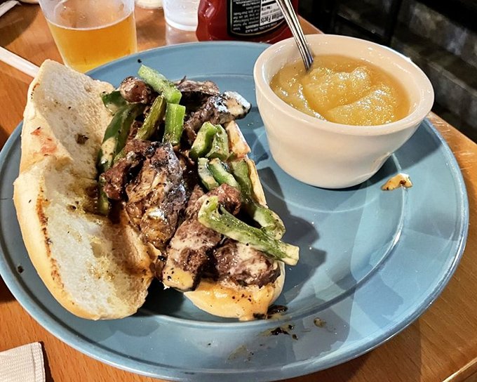 This steak sandwich with green peppers isn't just lunch—it's an edible masterpiece. The side of applesauce offers a sweet counterpoint to the savory star.