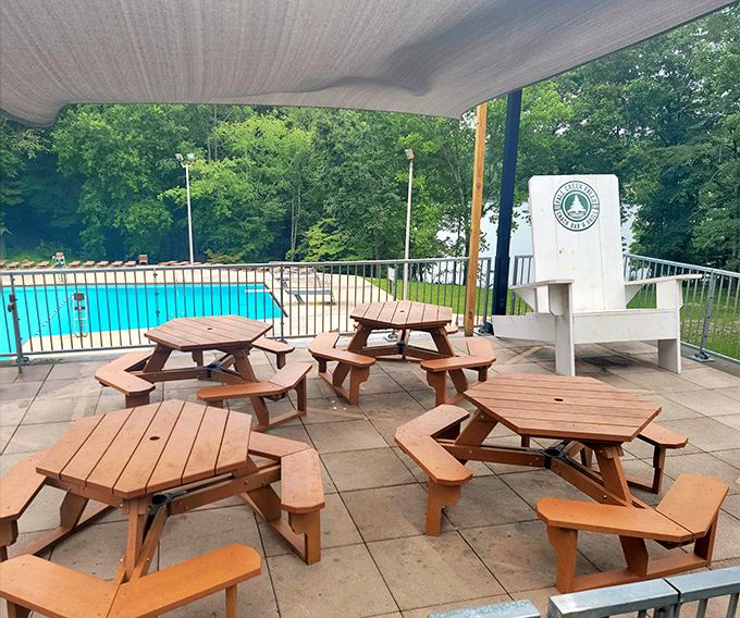 The pool area's wooden tables offer front-row seats to summer splashing, proving that sometimes the best entertainment doesn't require charging cables.