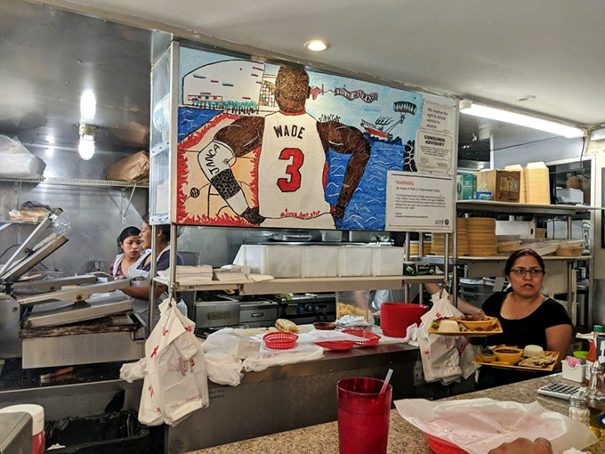 Where the magic happens. Behind the counter, Miami Heat memorabilia watches over the culinary wizards who transform simple ingredients into legendary meals.