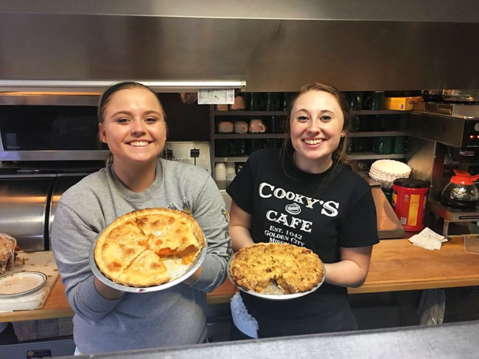 The staff proudly displaying their handiwork&mdash;homemade pies that aren't just desserts but edible ambassadors of Golden City's hospitable spirit.
