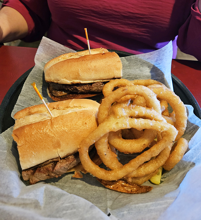 Two sandwiches and onion rings that could make a food photographer weep with joy. The basket presentation says casual; the execution screams expertise.