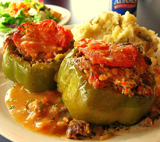 Stuffed peppers that your grandmother would approve of, swimming in a sauce worth sopping up with every available carb within reach.