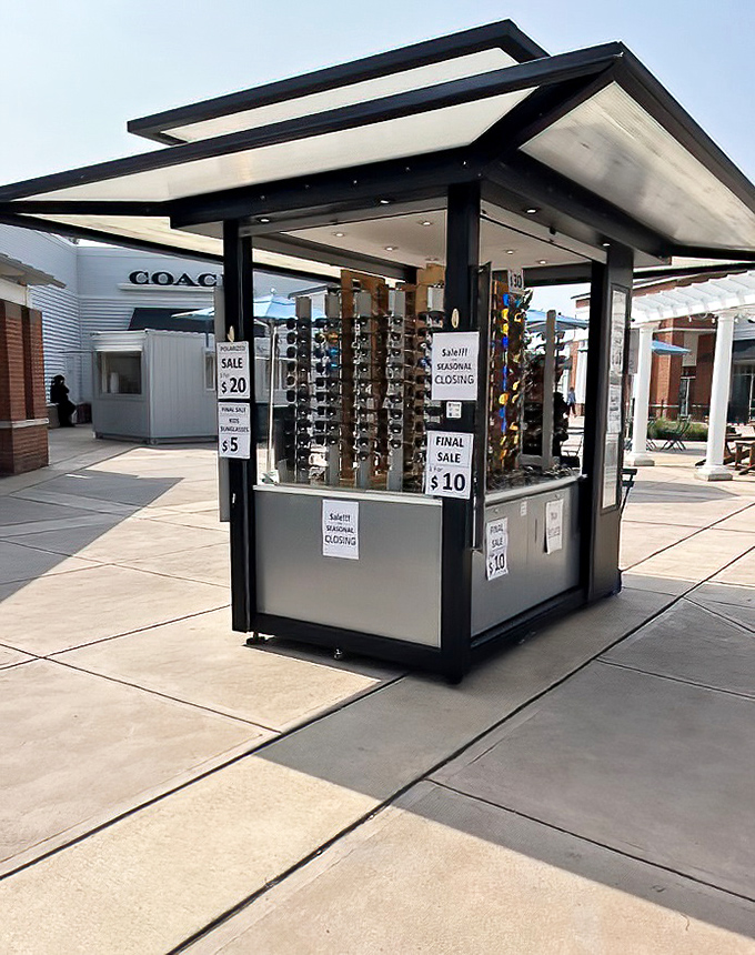 Sunglasses kiosk basking in the sunshine, offering protection from both UV rays and full retail prices. Fashion and function in perfect harmony.