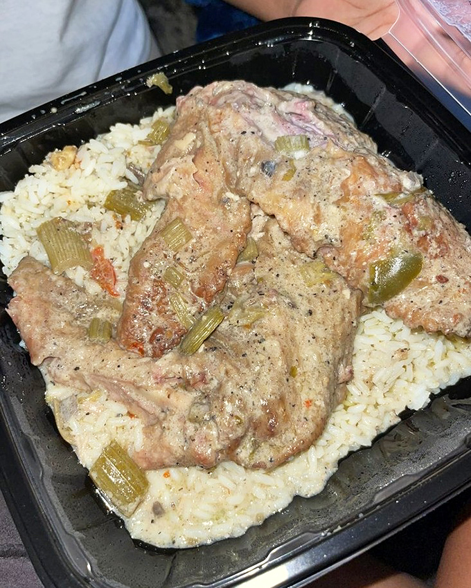 Smothered turkey wing resting on rice &ndash; comfort food engineering at its finest, where gravy becomes an essential food group.