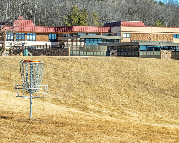Even recreational amenities in Baraboo embrace the landscape, with this disc golf basket standing ready for players amid the golden winter grass.