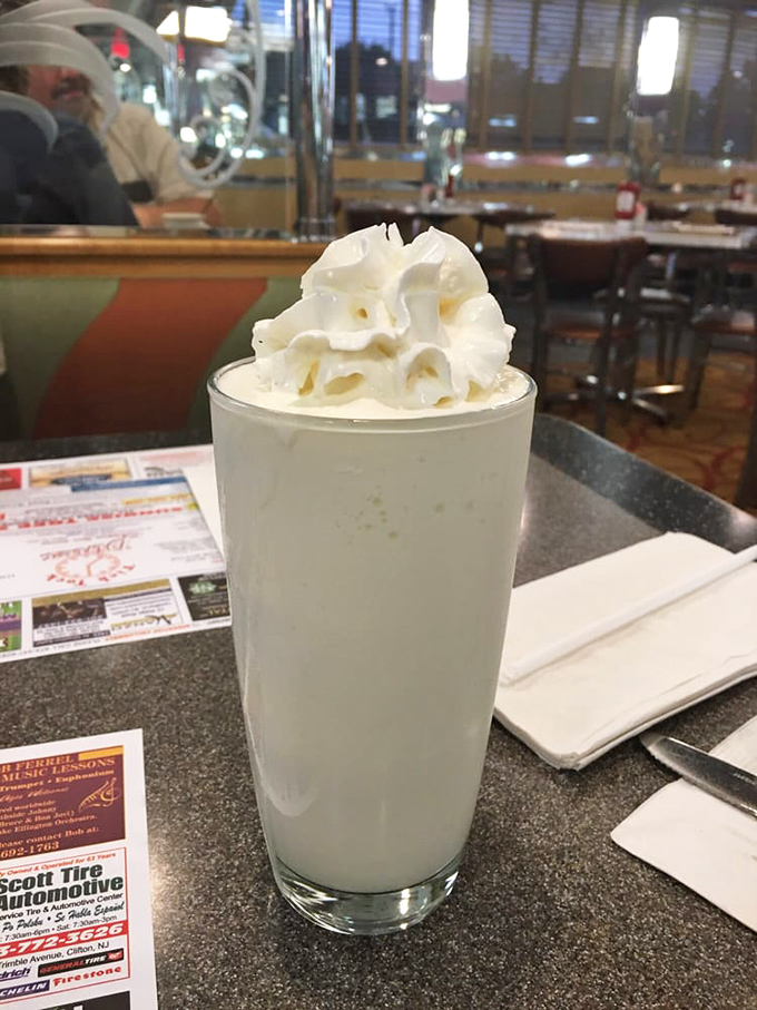 A milkshake so thick it defies physics and your straw's best efforts—topped with whipped cream that's basically wearing a cloud as a hat.
