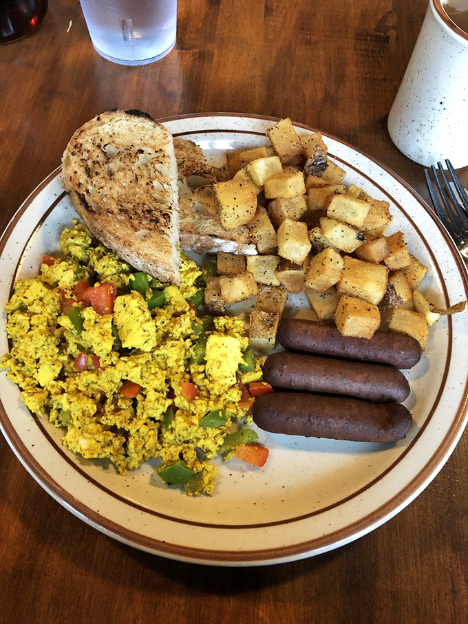 A hearty breakfast plate that says "You won't be hungry again until dinner"&mdash;scrambled eggs with veggies, perfectly seasoned potatoes, and sausage links standing at attention.