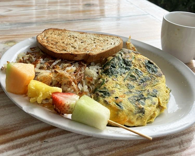 A veggie omelet that proves eating your greens can be downright indulgent when paired with crispy hash browns and fresh fruit.