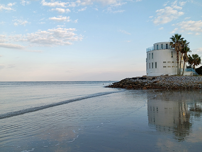 The iconic "Wedding Cake House" reflects in tidal waters like a dream. Part fortress, part fantasy &ndash; it's the kind of home that makes you wonder about its stories.