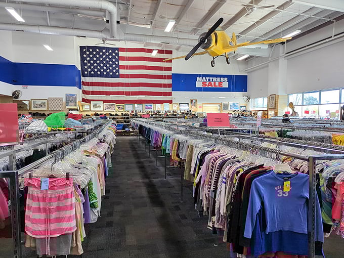 An American flag proudly watches over this sea of secondhand fashion. That yellow airplane might be the only thing not for sale!