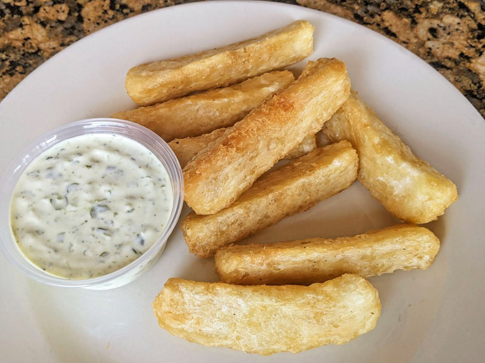 Golden yuca frita with creamy garlic sauce transforms humble cassava into crispy, addictive bites that disappear faster than vacation days.