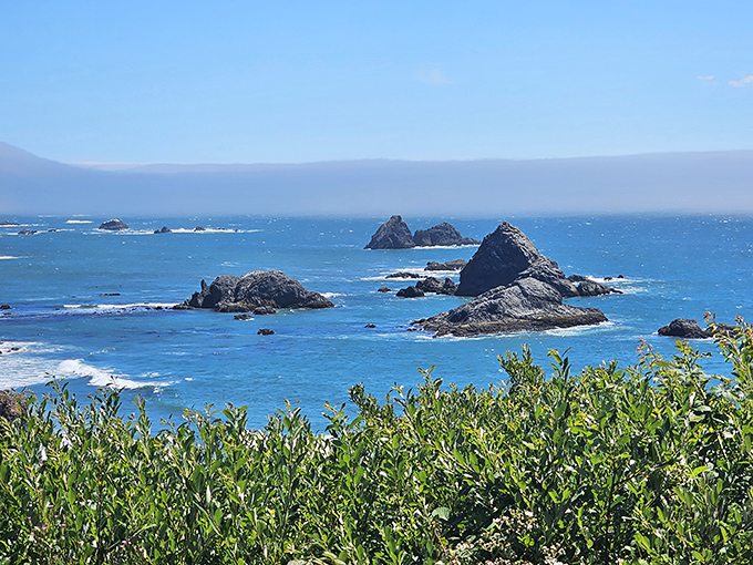 The Oregon coast's famous sea stacks create a jagged silhouette against the blue horizon, like nature's own abstract sculpture garden.