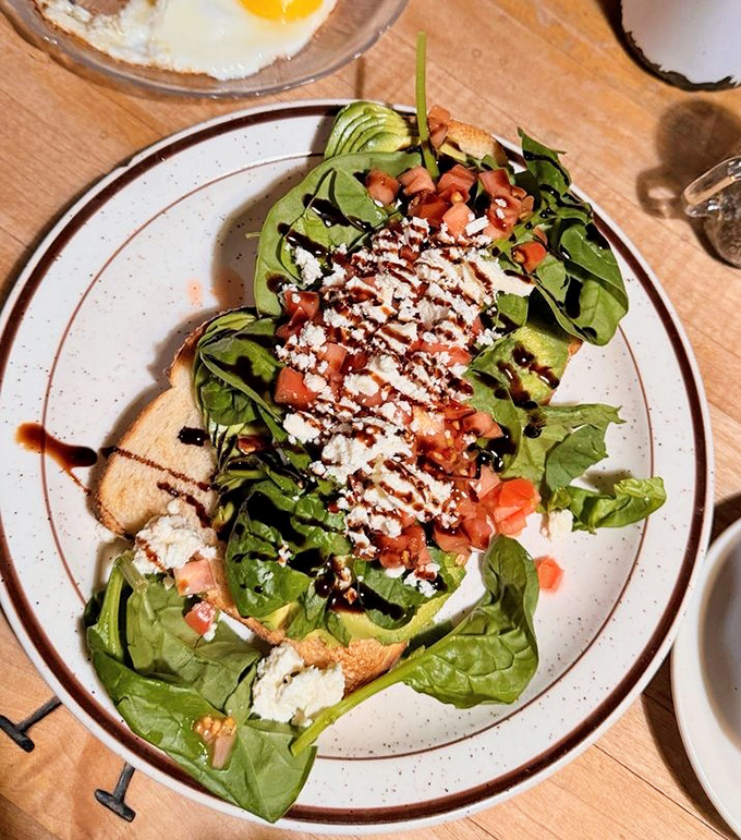 This isn't just avocado toast&mdash;it's California's edible business card, dressed up with fresh greens, tomatoes, and a balsamic drizzle.