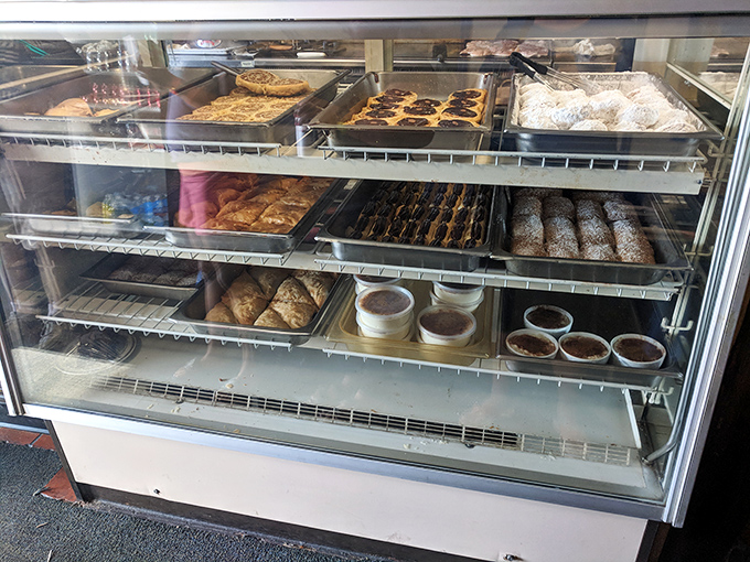 The pastry case stands as a monument to sweet temptation &ndash; each tray promising the perfect ending to your Greek feast.